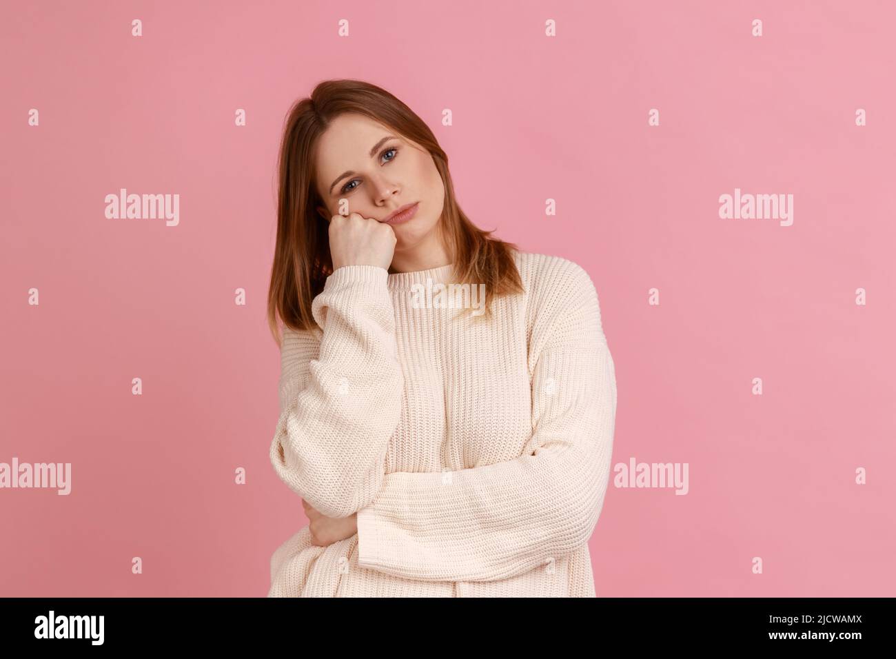 Portrait of blond woman leaning on hand and expressing disinterest ...