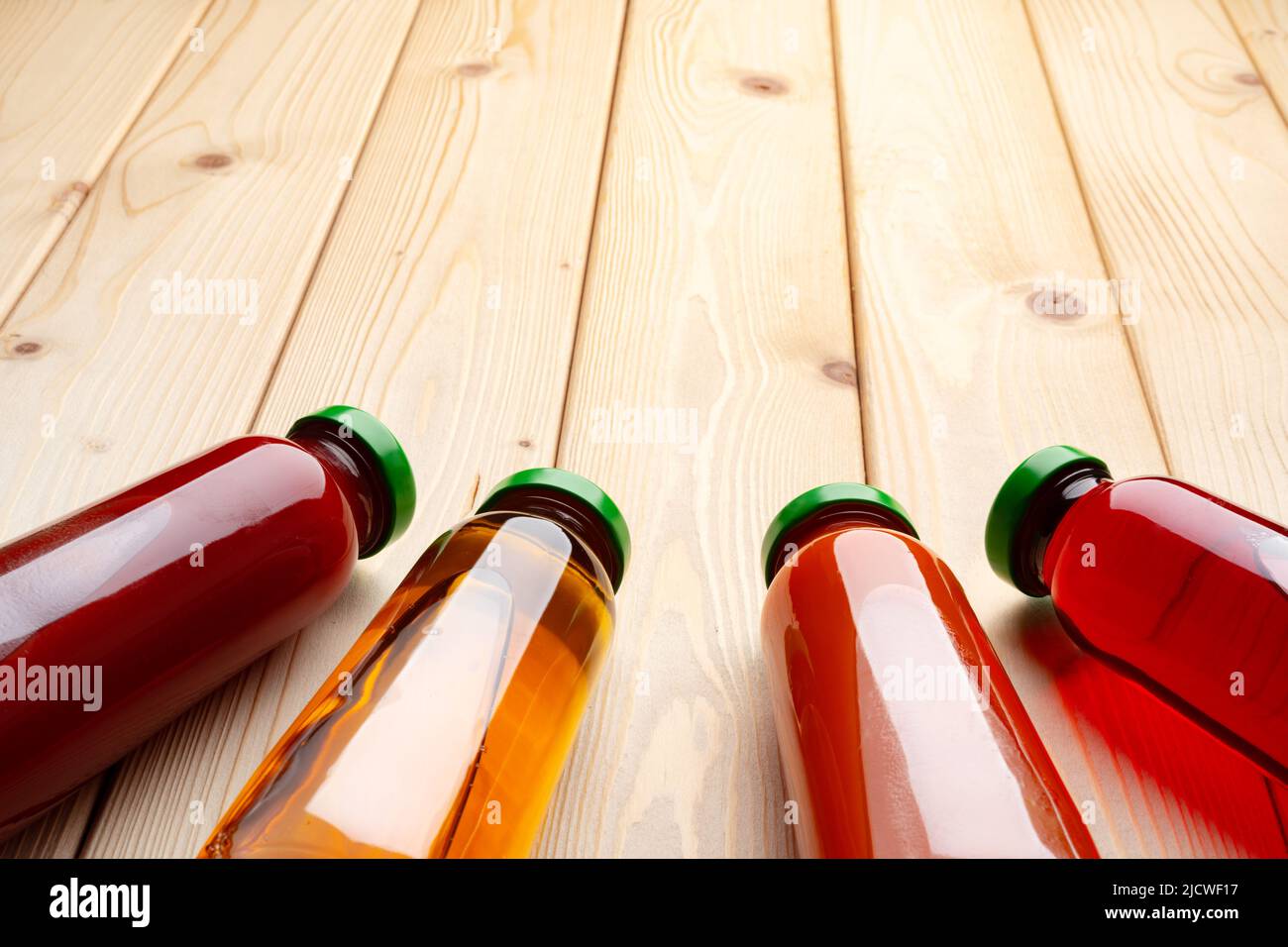 Different bottles of juice on wooden table Stock Photo - Alamy