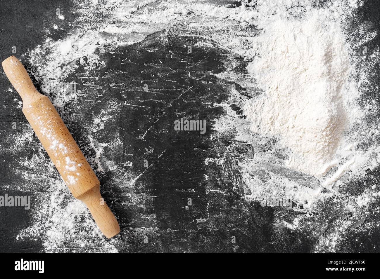 Scattered flour with rolling pin on black background Stock Photo - Alamy