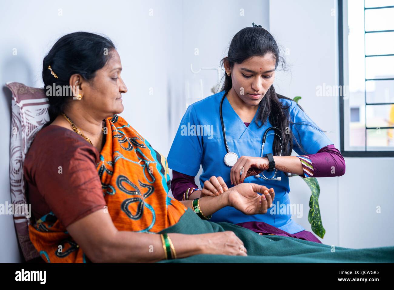 close up shot of doctor counting pulse by holding hand of sick patient ...