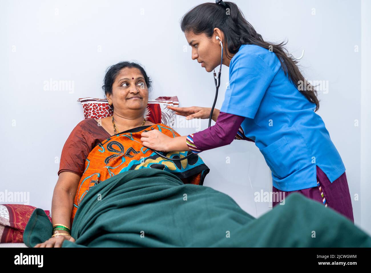Nurse checking health of middle aged woman at nursing home using ...