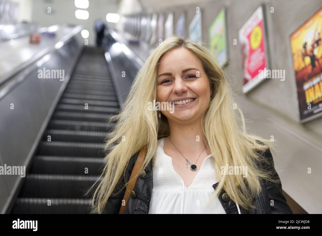 Pretty Blonde Woman Smiling on an Escalator into the Subway Stock Photo ...