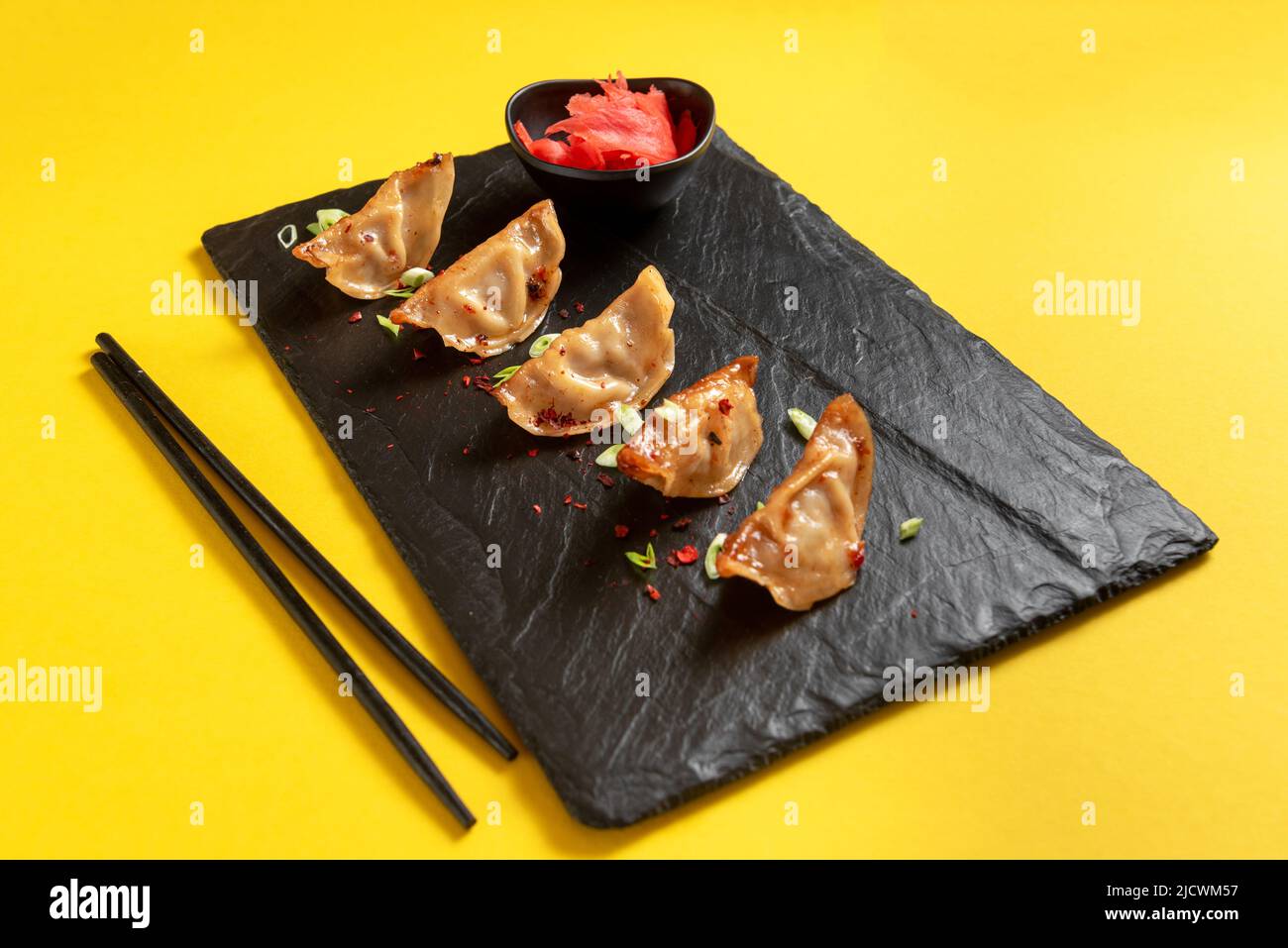 Original Japanese dumplings Gyoza with green onion on the yellow ...