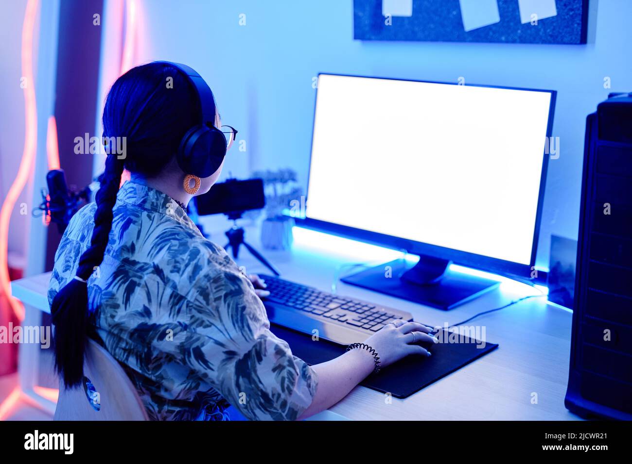 Portrait of teenage girl playing video games at night with computer ...