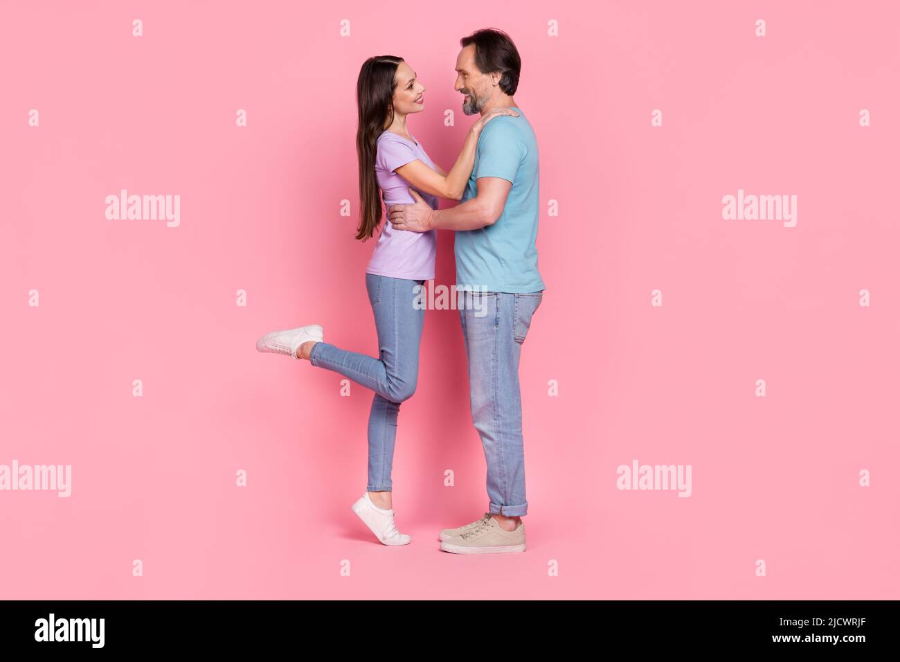 Full body profile portrait of two positive satisfied partners embrace ...
