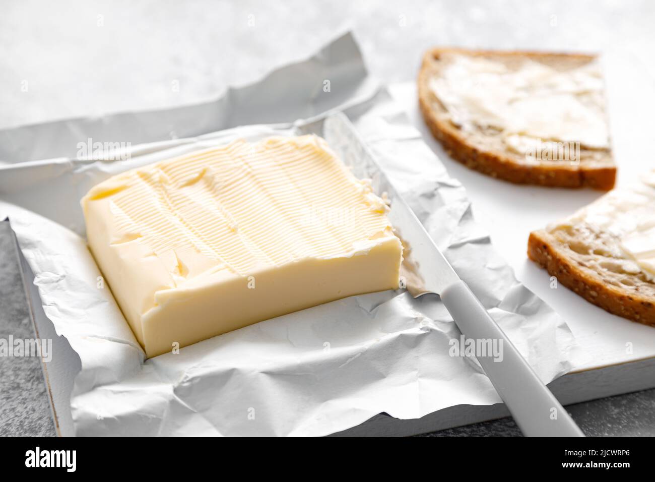 Block of butter with butter knife in a open pack. Buttering bread Stock ...