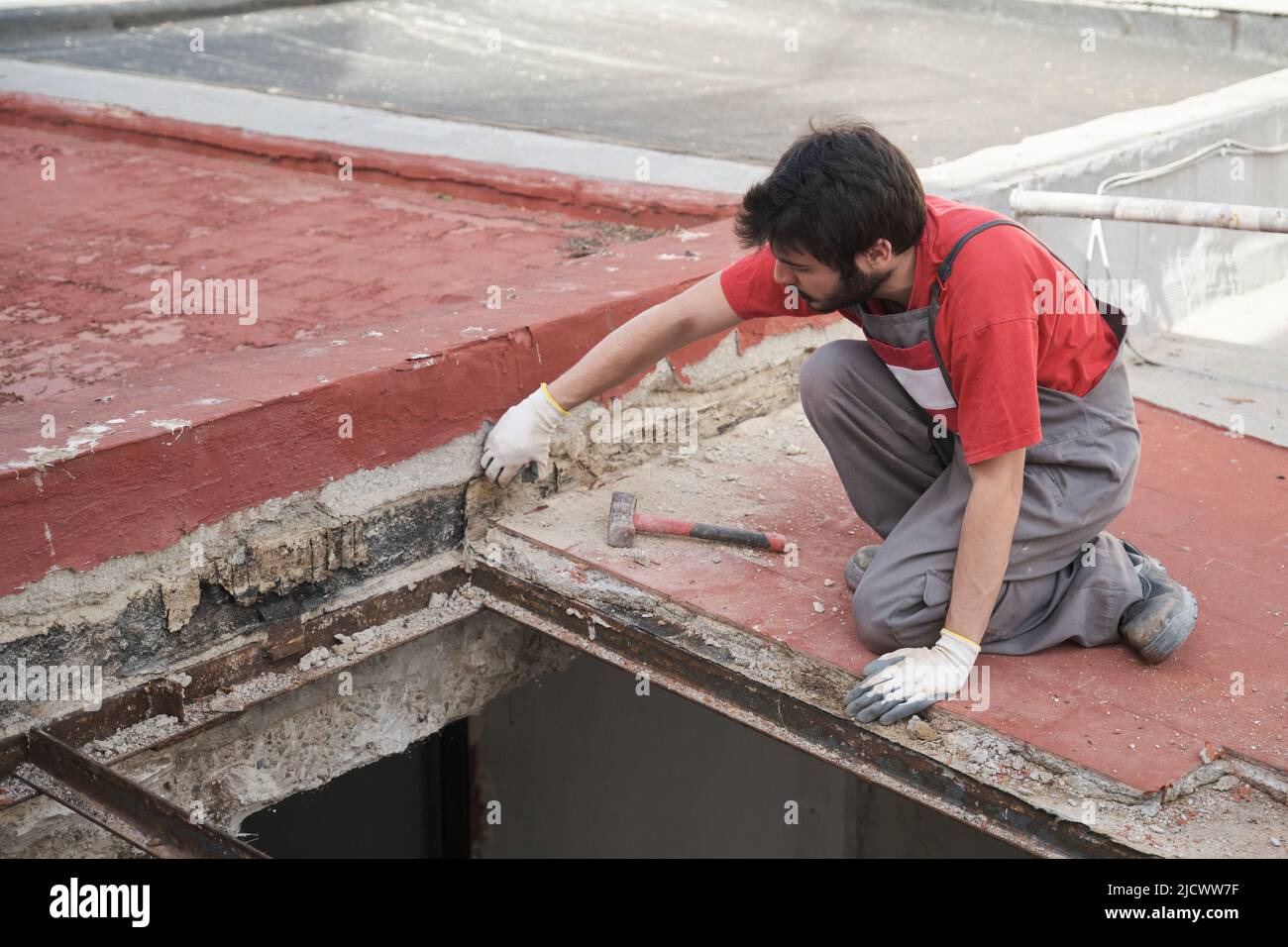 Young man tearing the roof of a house down Stock Photo - Alamy