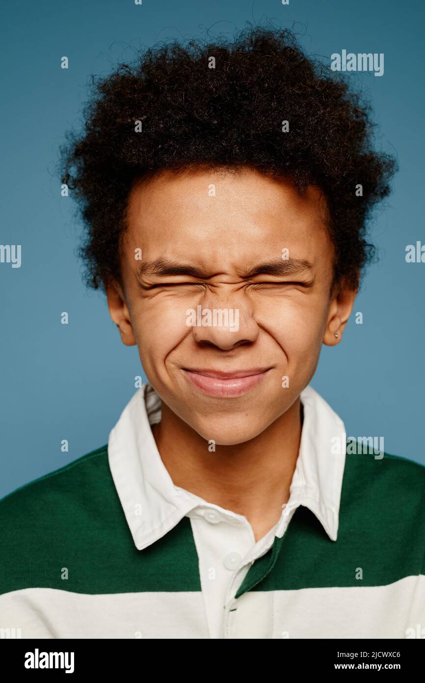 Vertical close up portrait of black teenage boy facing camera with eyes ...