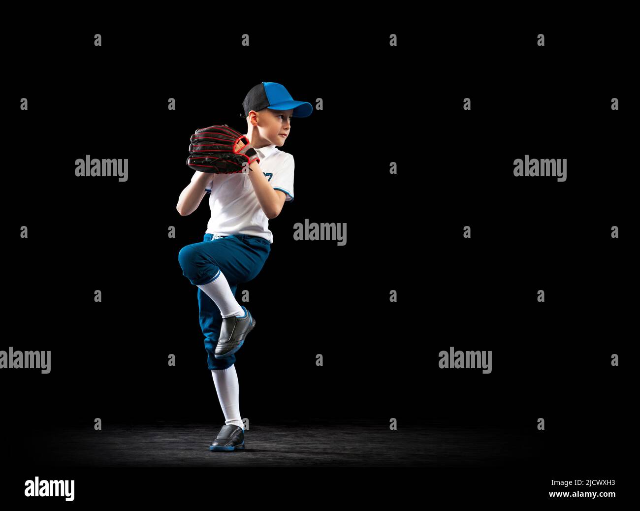 Dynamic portrait of little baseball player, pitcher in blue-white ...