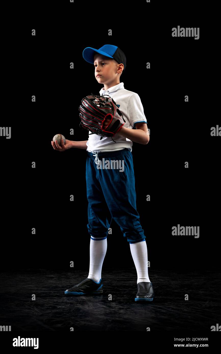 Portrait of kid, beginner baseball player in sports uniform posing with ...
