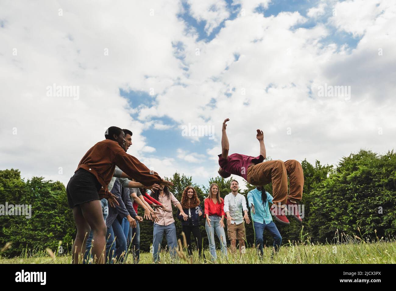 Young multiracial friends having fun doing stunts outdoor Stock Photo ...