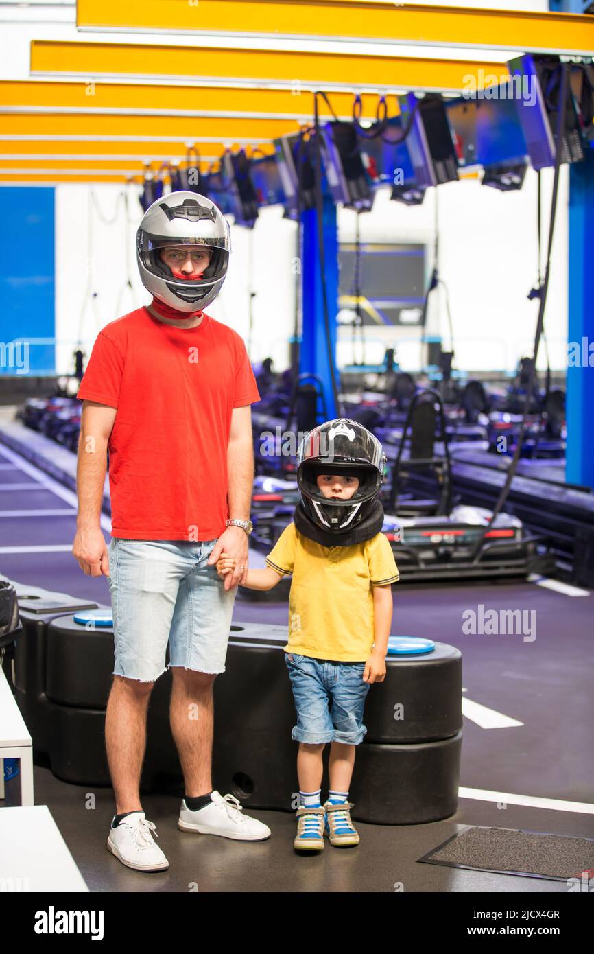 Father and child, son, preparing to ride gokart carting car race ...