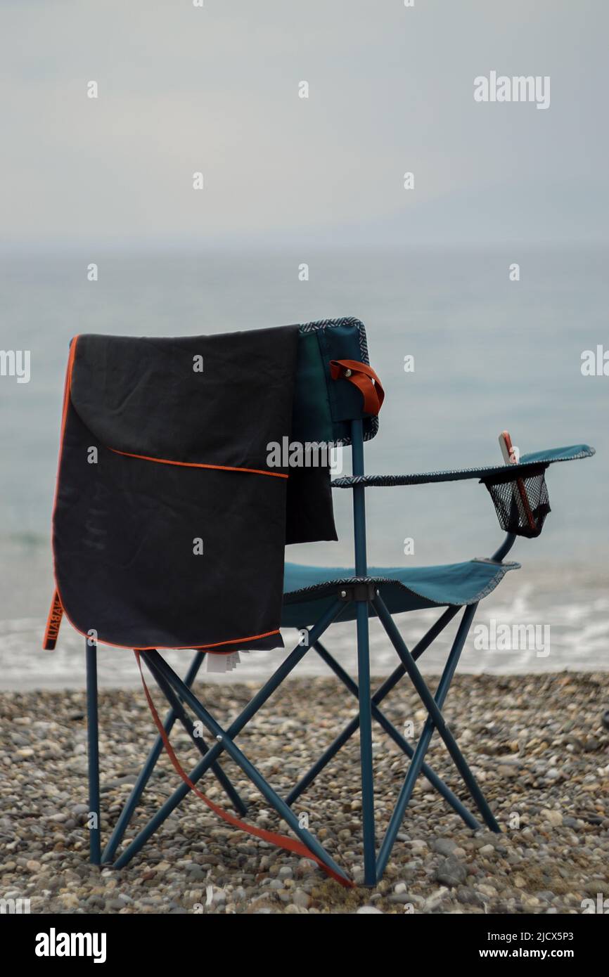 Collapsible beach chairs on pebble stone beach Stock Photo - Alamy