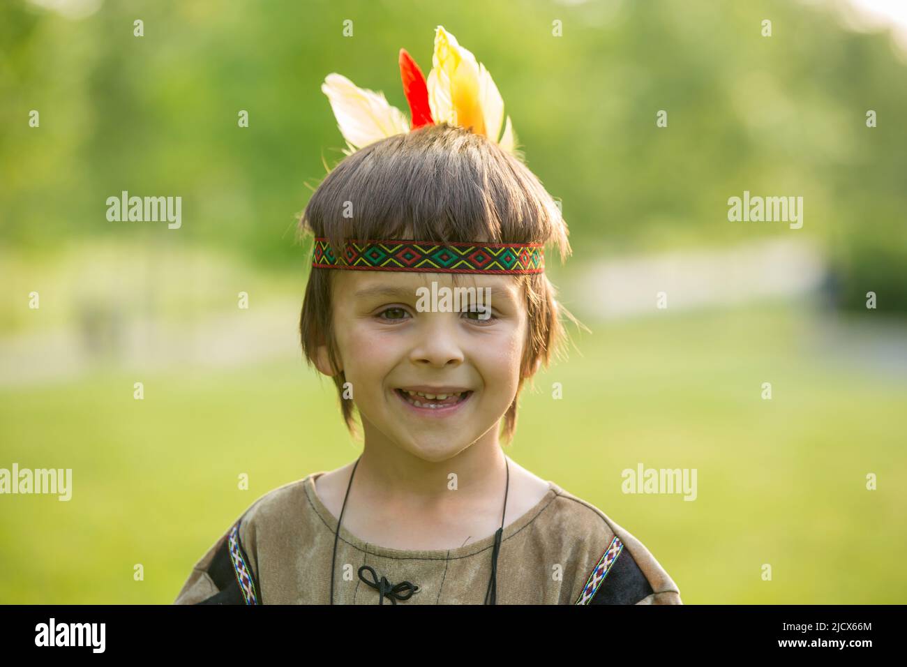 Cute portrait of native american boy with costumes, playing outdoor in ...