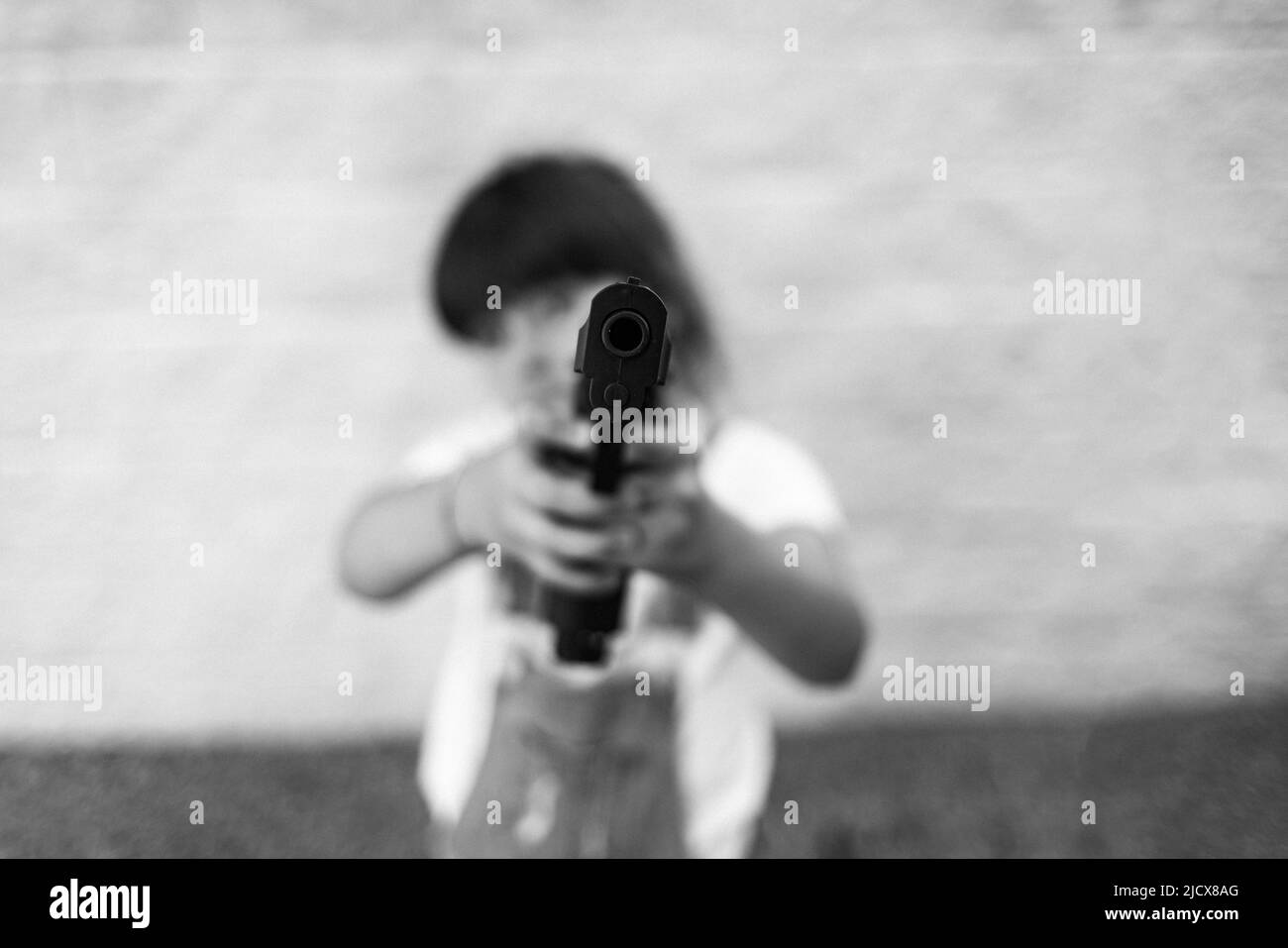 Black and white photography with a little girl pointing a gun. Concept ...