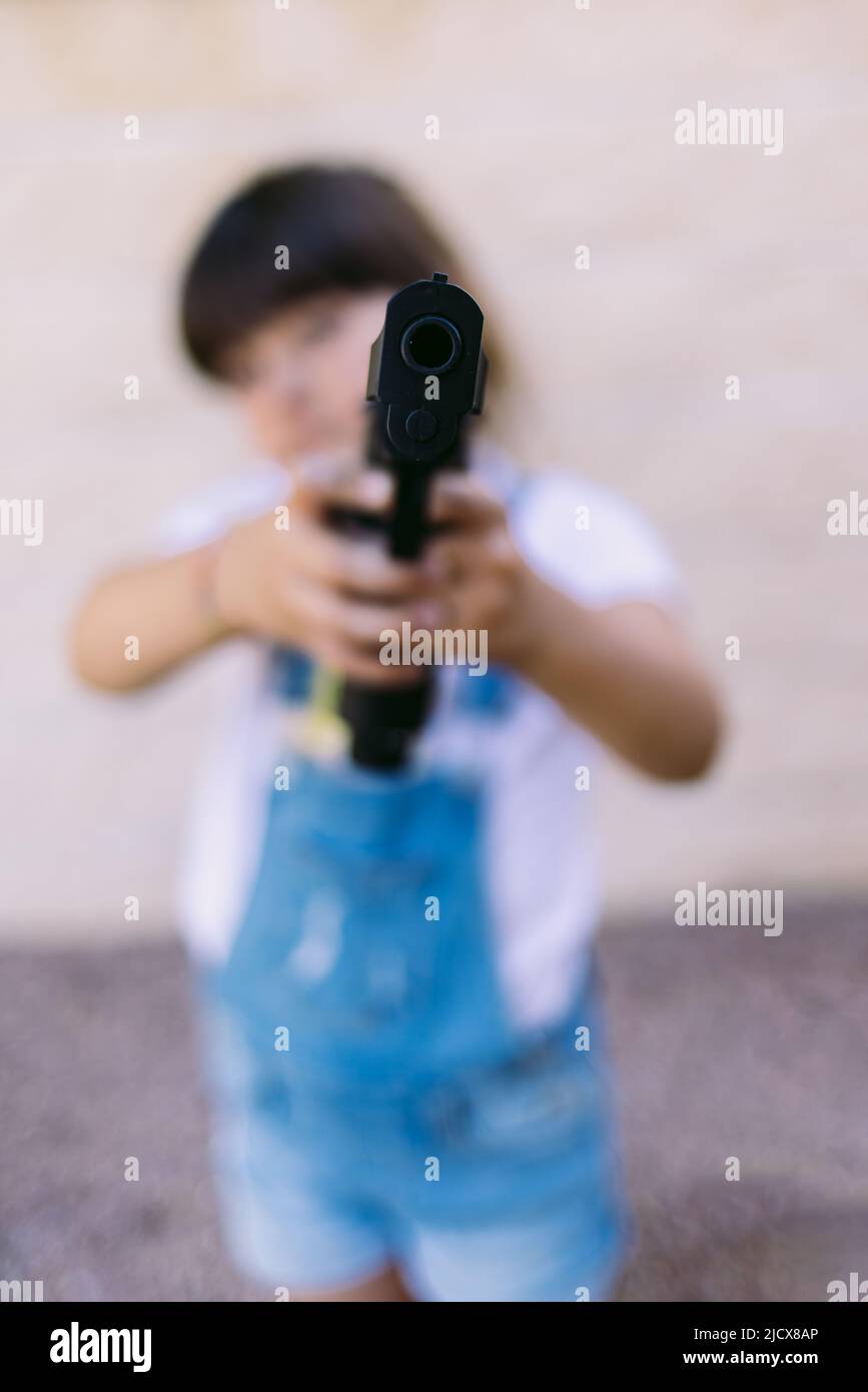 Little girl pointing a gun. Concept of violence, weapons, guns ...