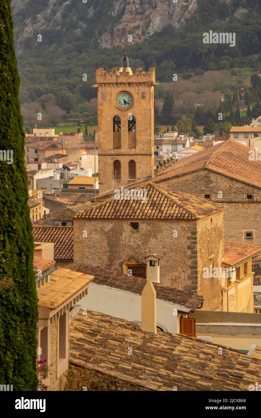 View of church clock tower and rooftops in the old town of Pollenca ...