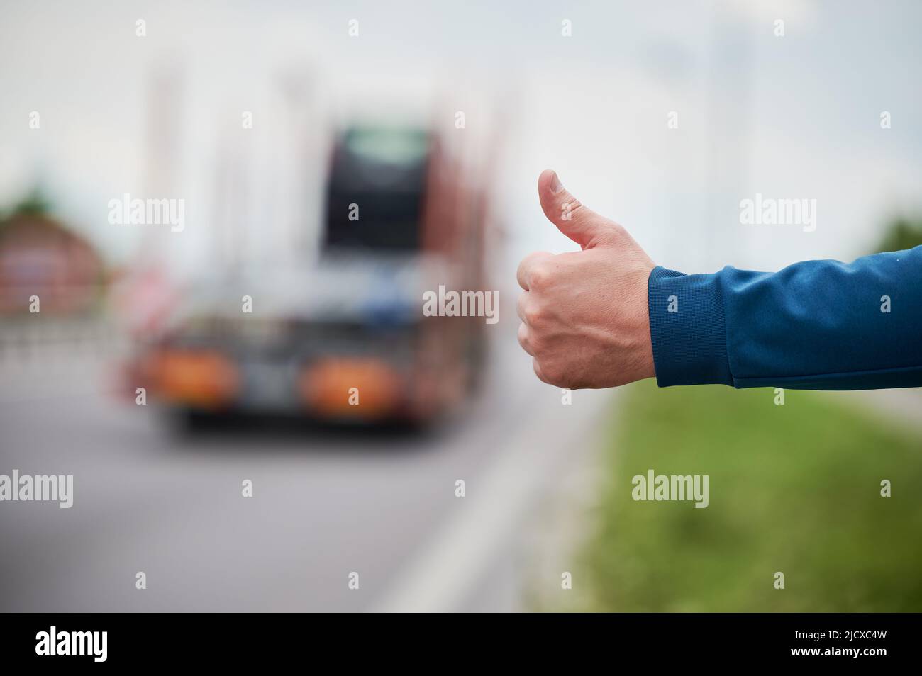 Close up of man's hand hitchhiking by roadside. Male hand showing ...