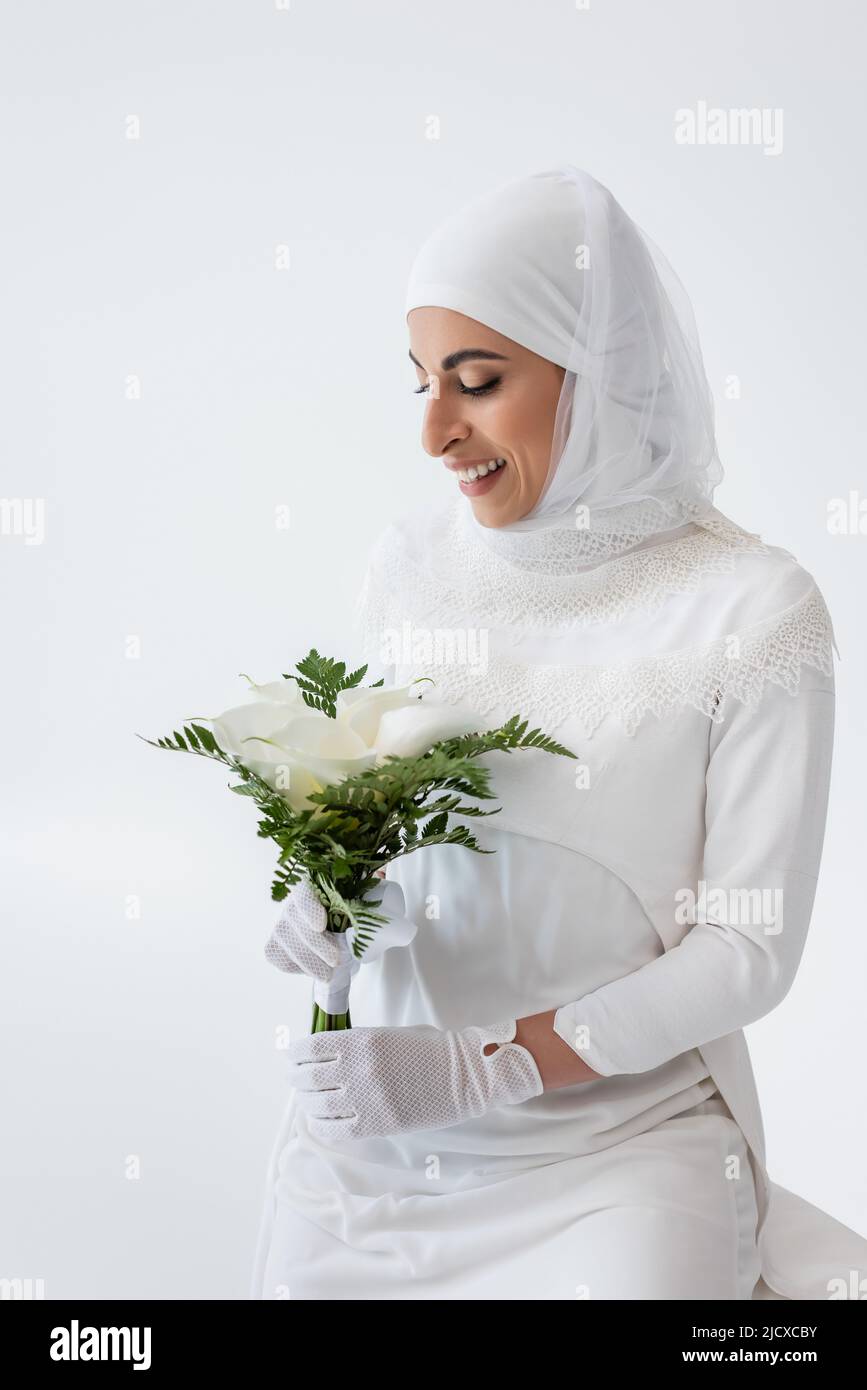 happy muslim bride in gloves and wedding dress holding calla lily ...