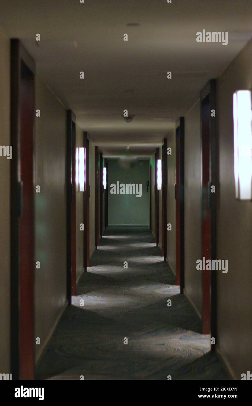 A typical and common hotel hallway lined with lights and doors Stock ...