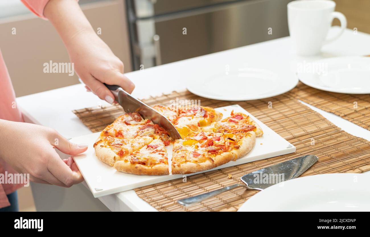 close-up homemade pizza being cut with a kitchen knife Stock Photo - Alamy