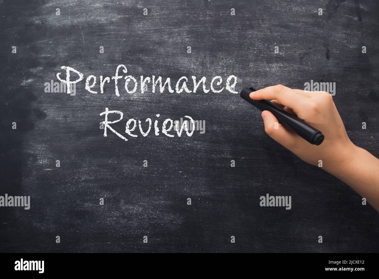 Woman points to words Performance Review on chalkboard Stock Photo - Alamy