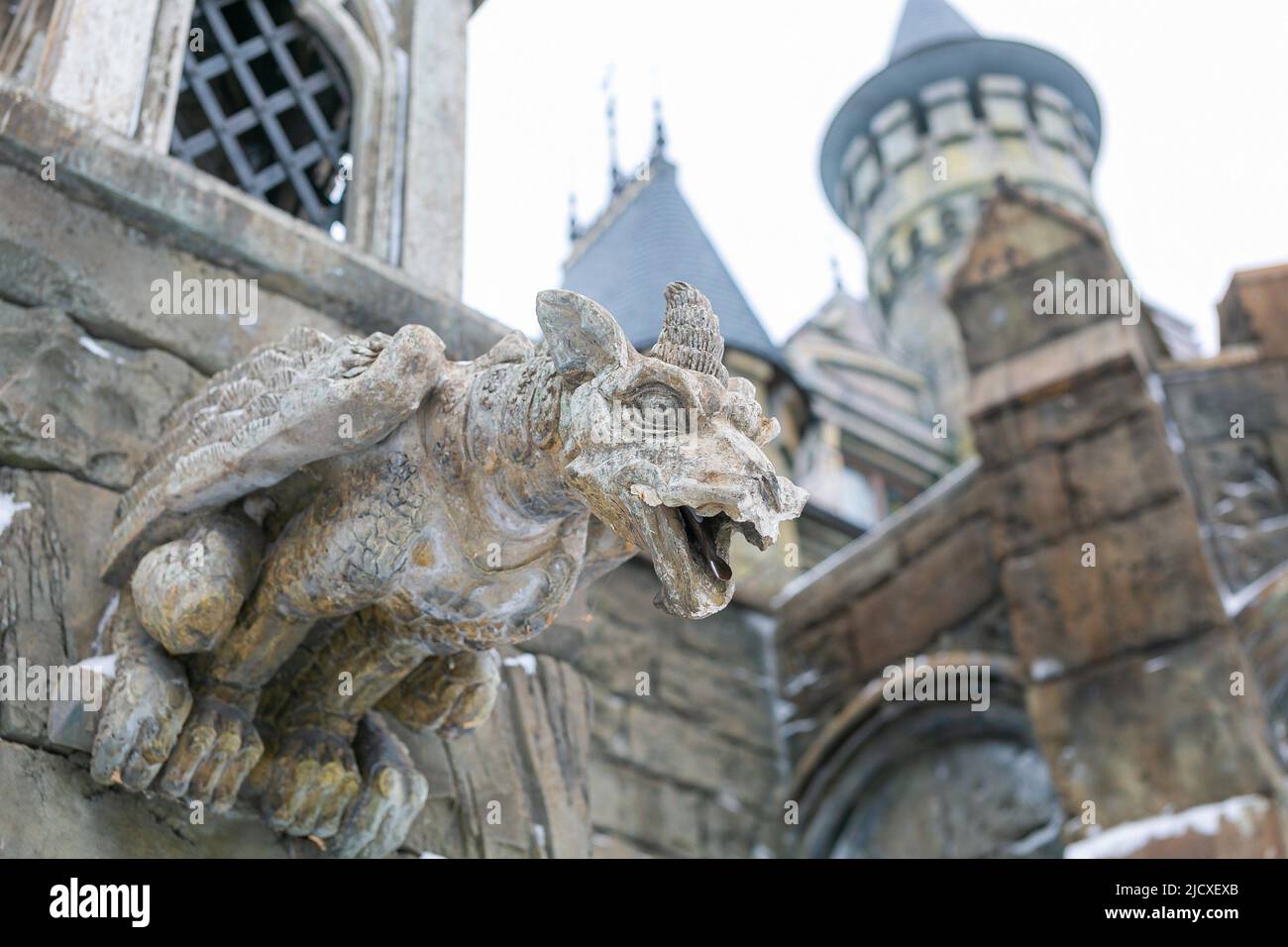 Gargoyle statue attached to the wall of the castle Stock Photo - Alamy