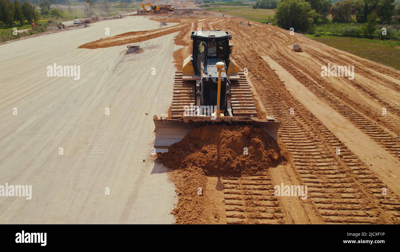 Drone shot, front view of a giant yellow bulldozer during a ...