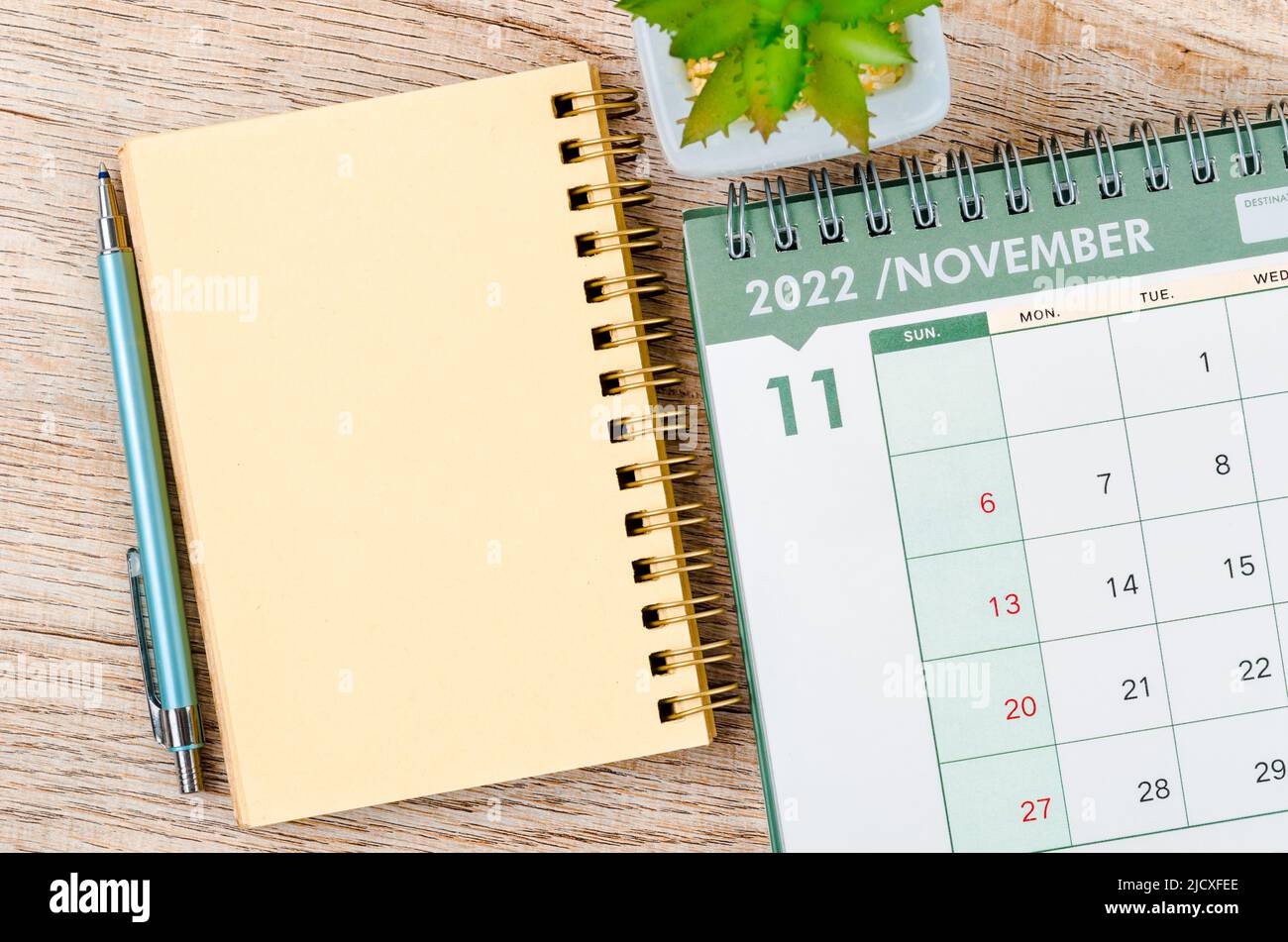 The November 2022 desk calendar and diary with small plant on wooden ...