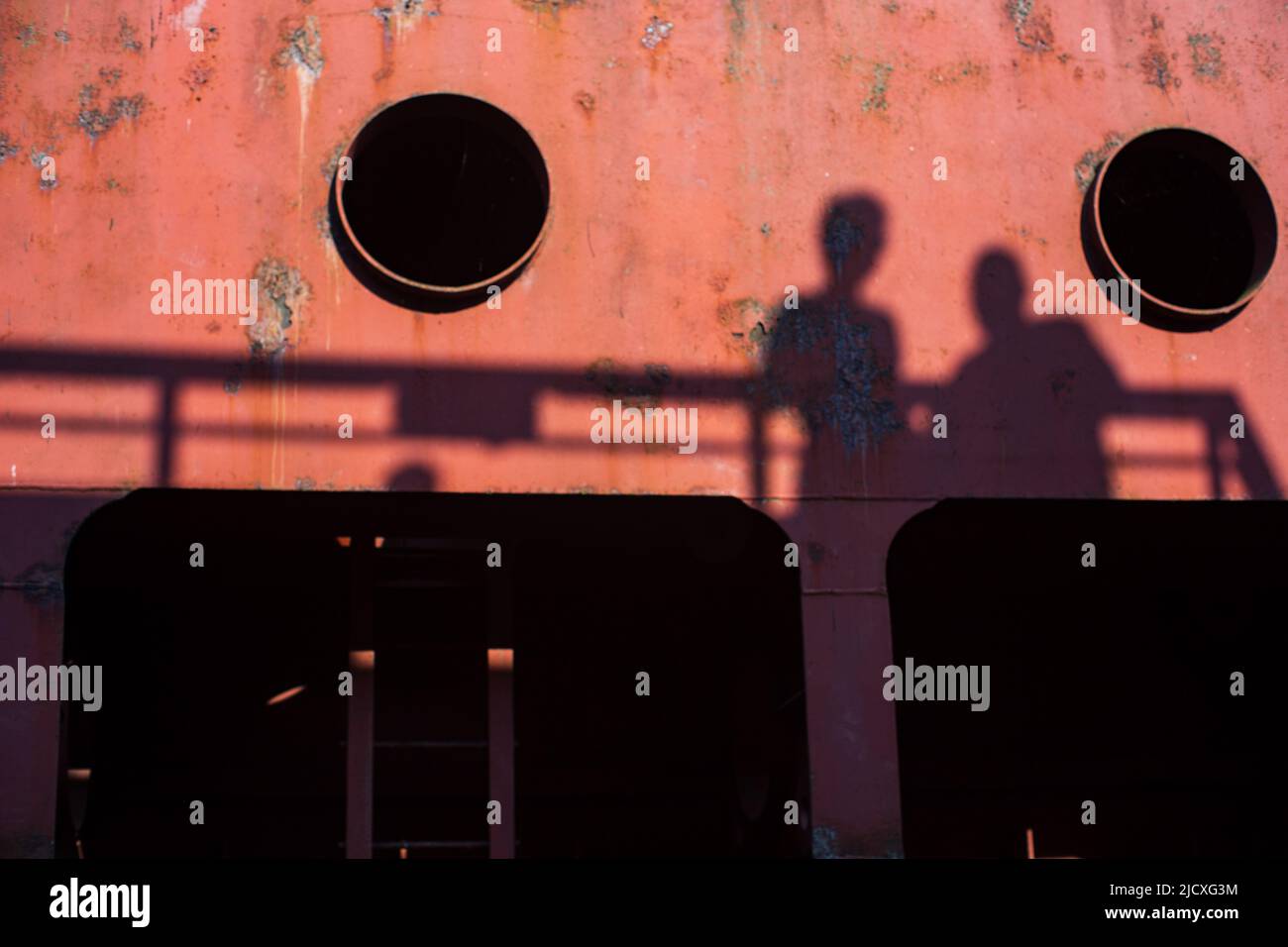 Blurred shadow of two people on the surface of a large metal ...