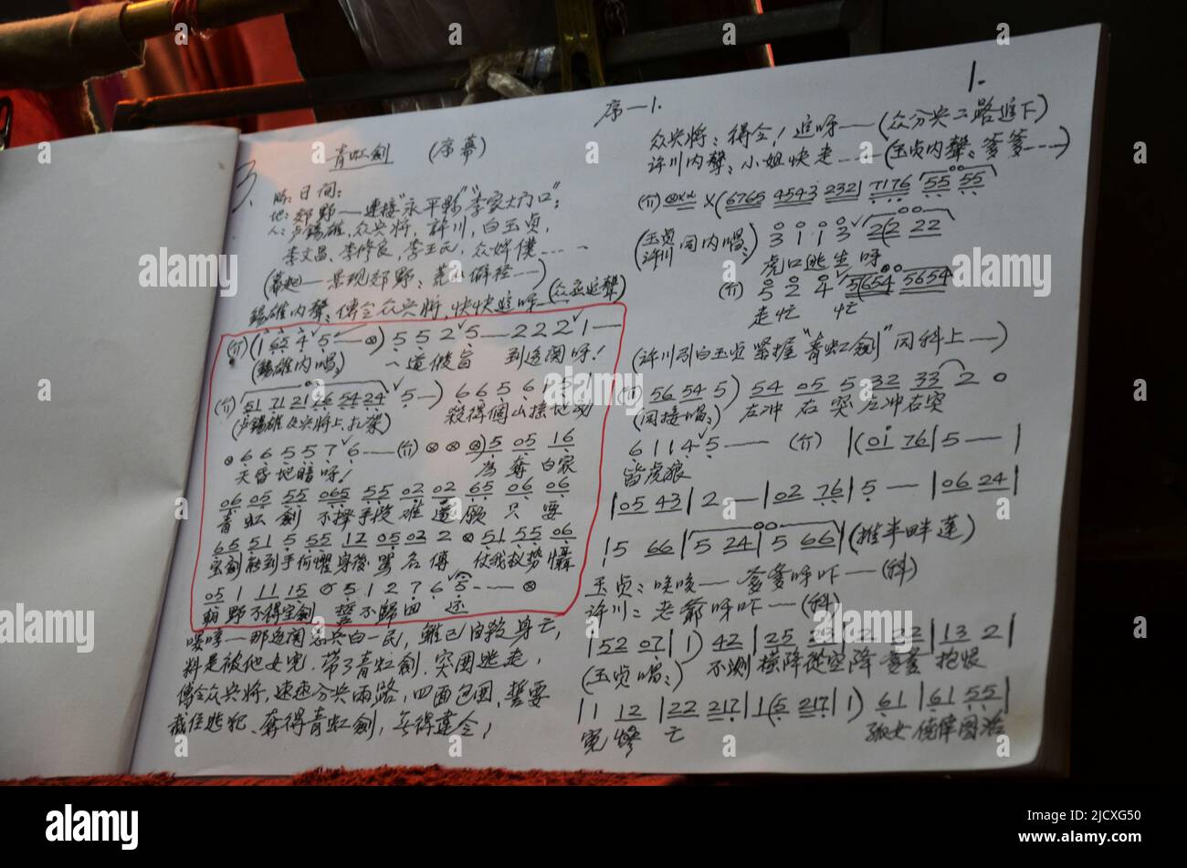 Chinese musician writing melody note on paper notebook and use playing ...