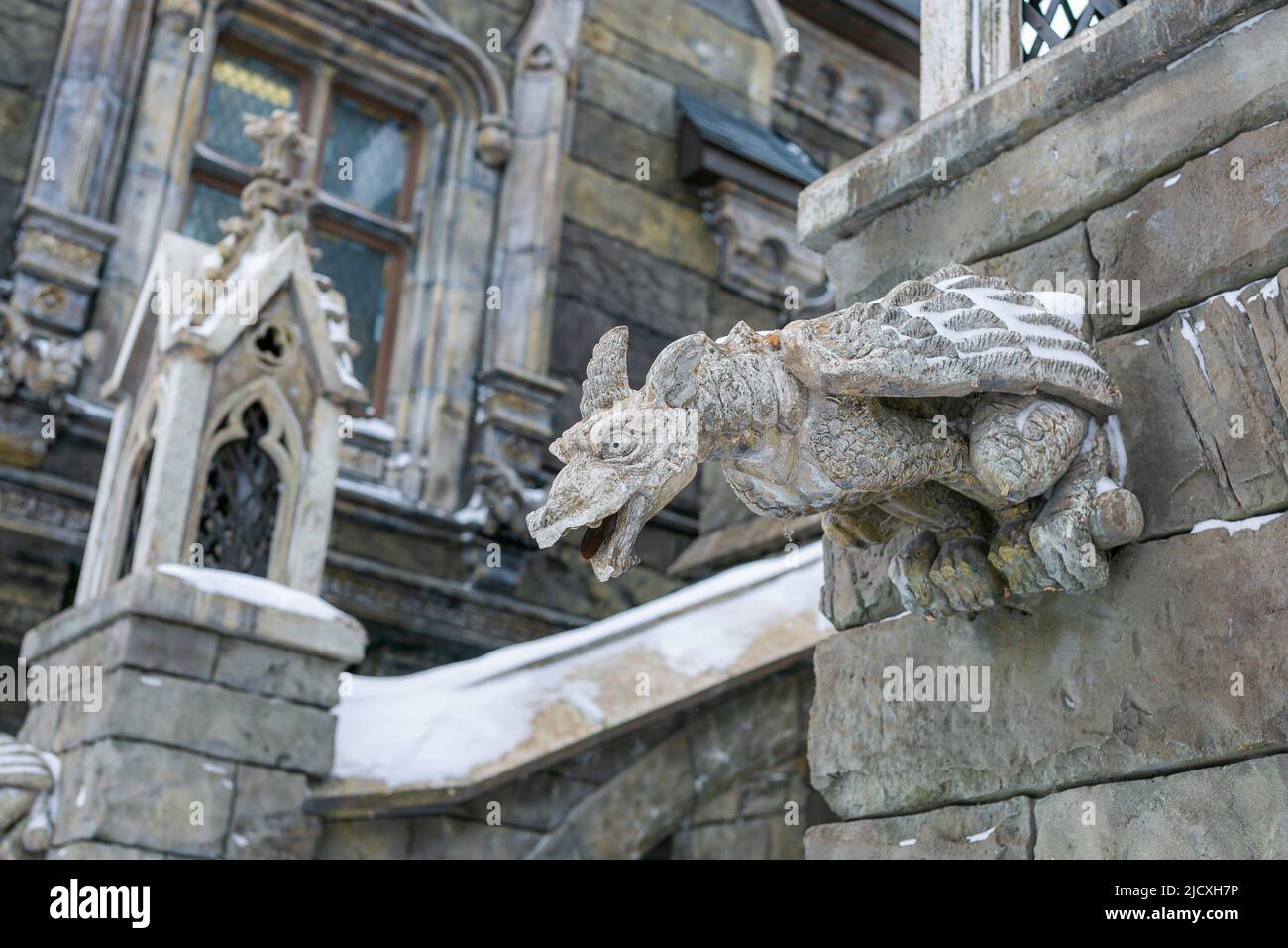 Gargoyle statue attached to the wall of the castle Stock Photo - Alamy