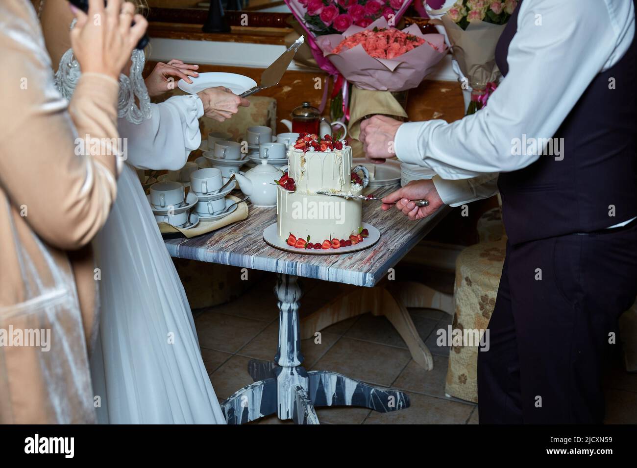 The bride and groom cut the cake Stock Photo - Alamy
