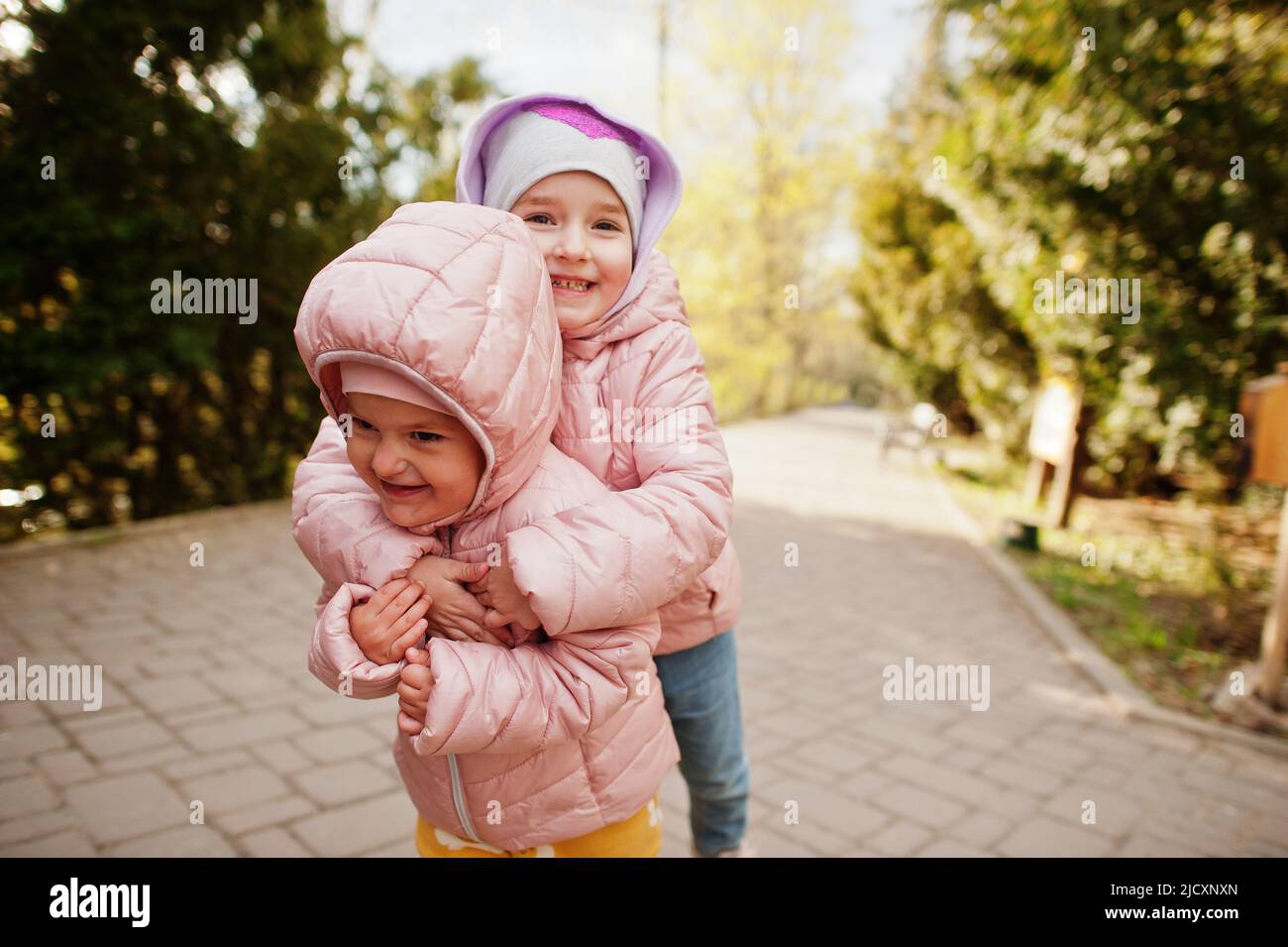 Two happy sisters hugs together outdoor Stock Photo - Alamy