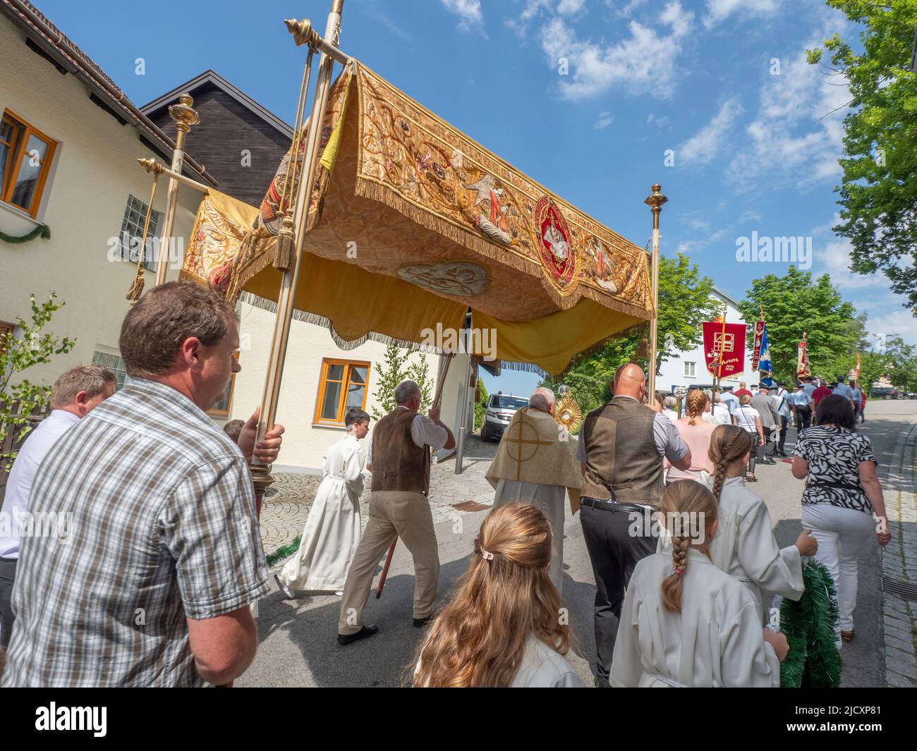 Participants of the procession carry a canopy over the priest ...