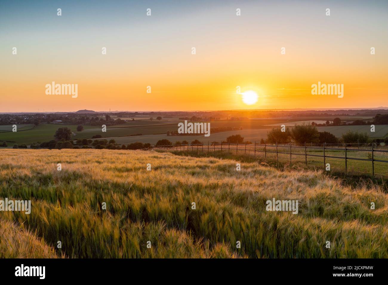 A golden sunset over the rolling hills in Banholt, south Limburg in the ...