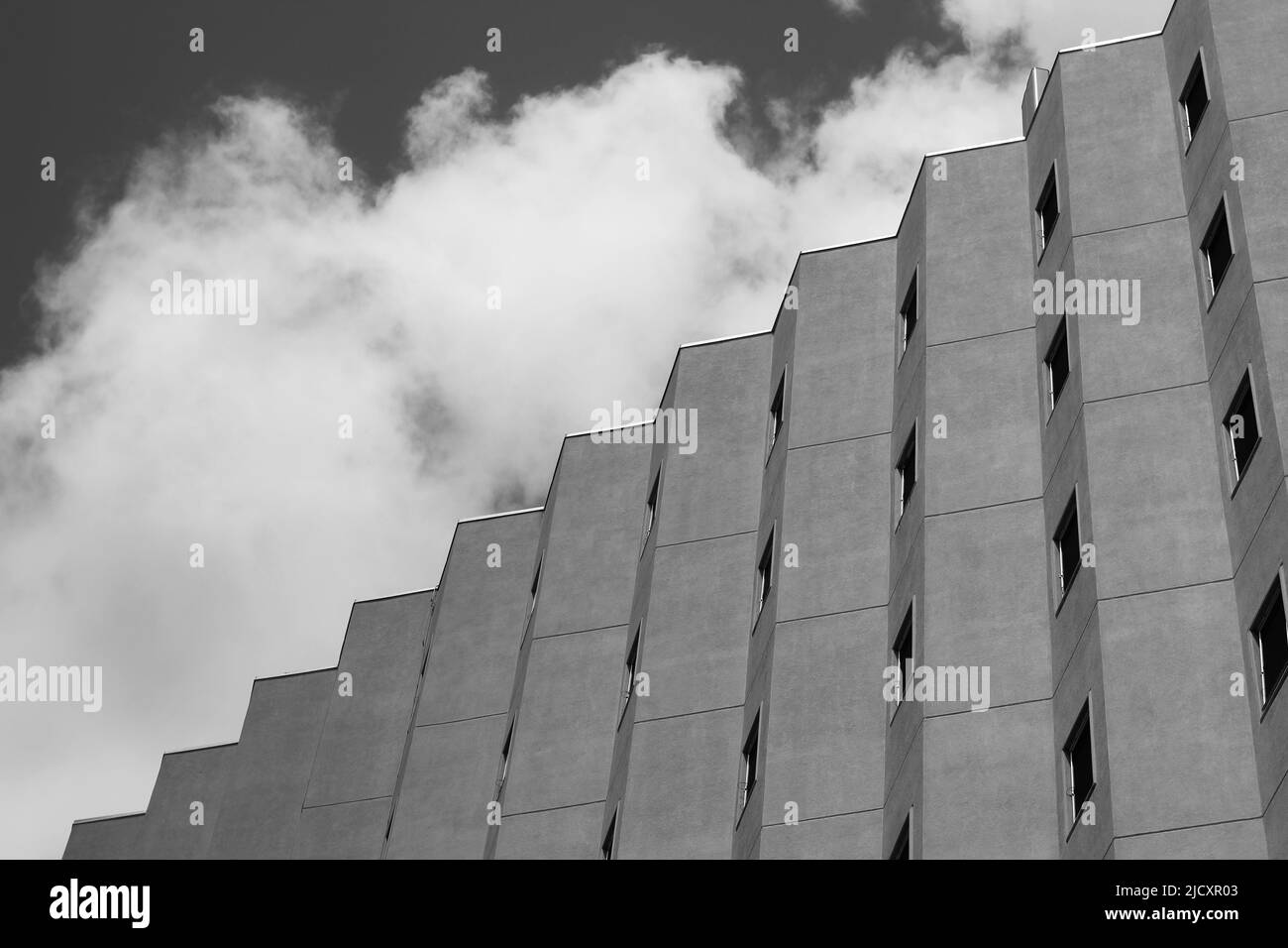 A minimalist view of a plain concrete building set against the tropical ...