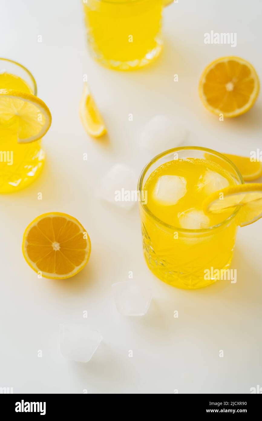high angle view of glasses with iced citrus tonic and cut lemons on ...