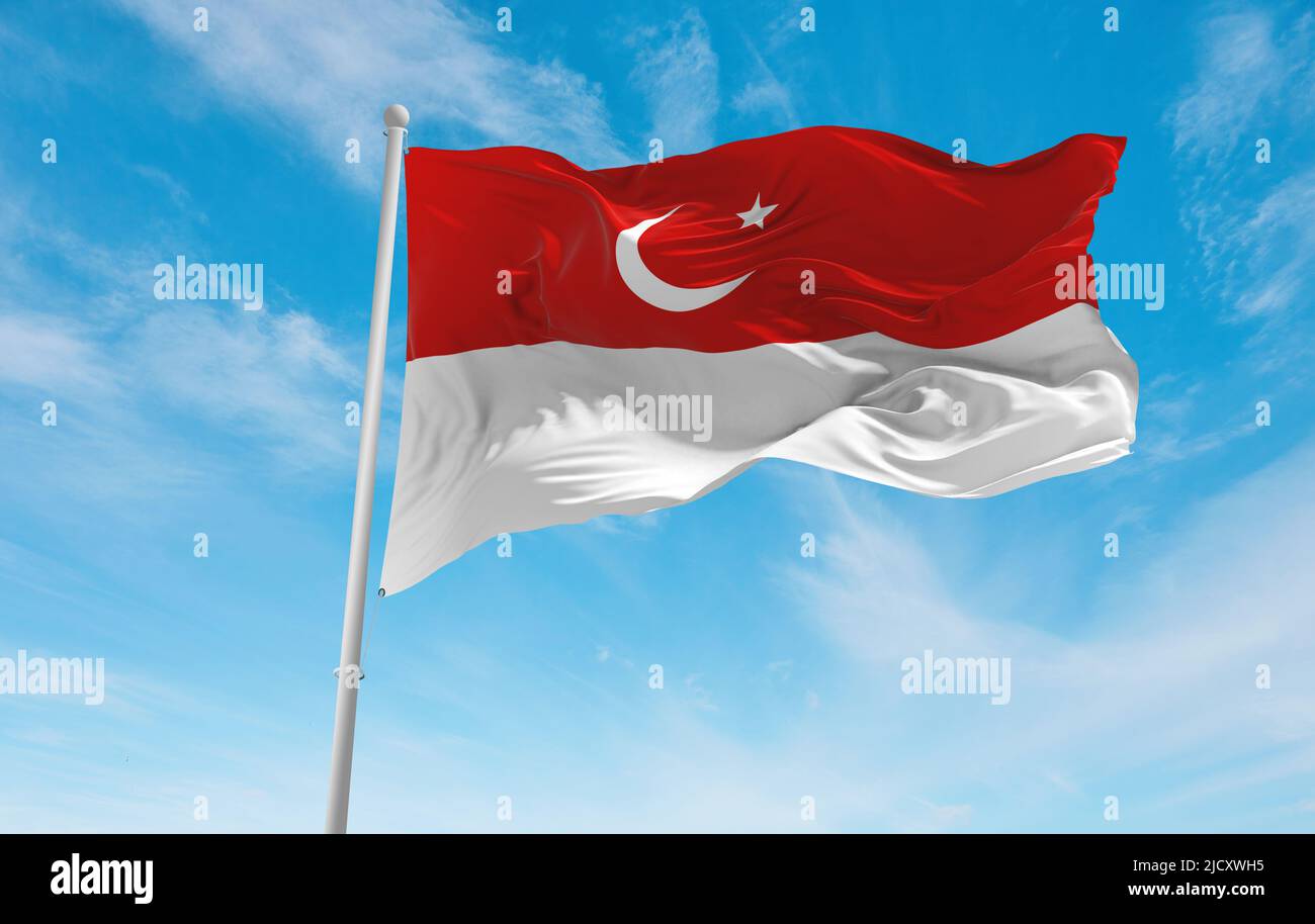 official flag of Islamic State Indonesia at cloudy sky background on sunset, panoramic view ...