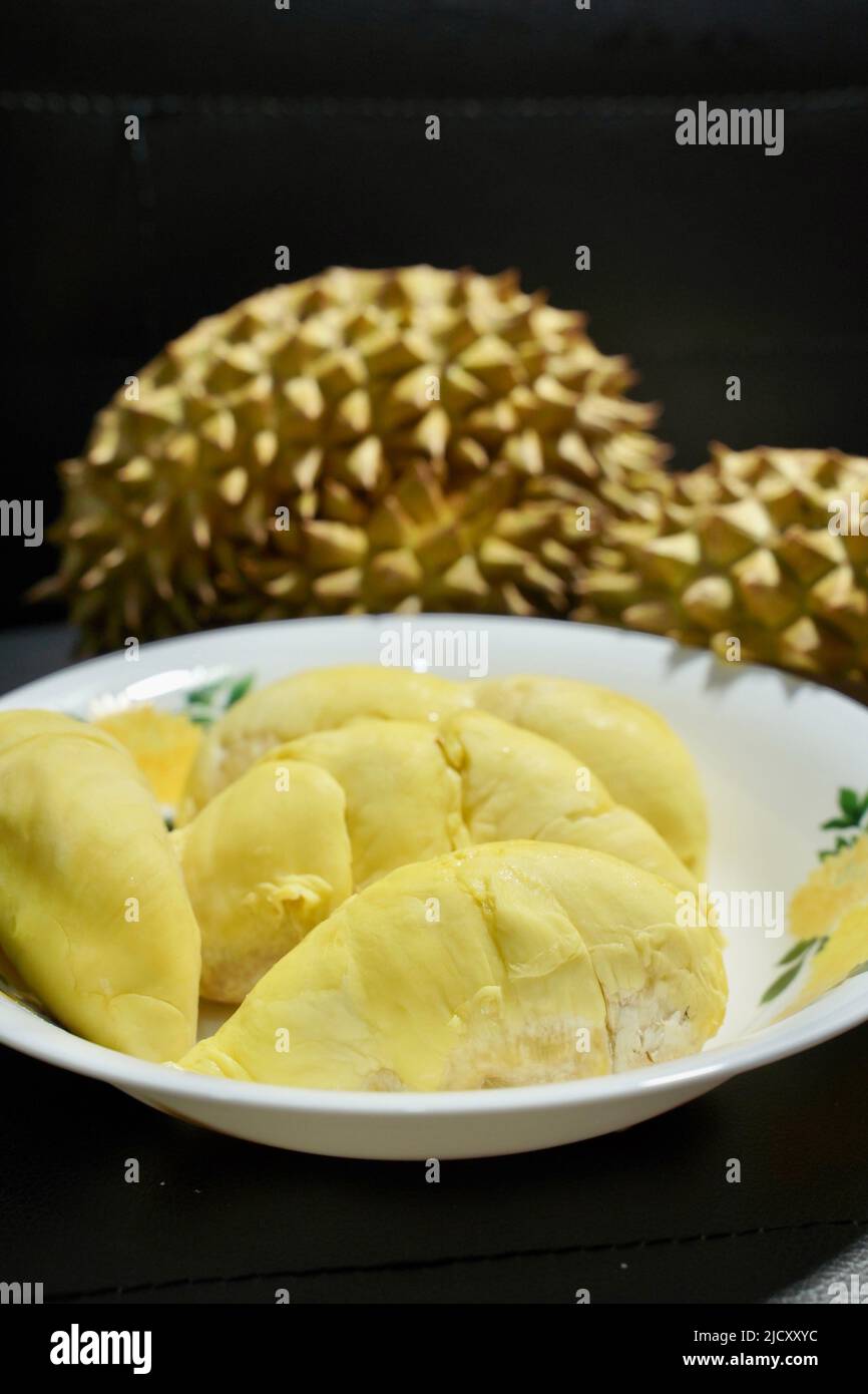 Fresh durian in packaging on white dish with durian peel on banner ...