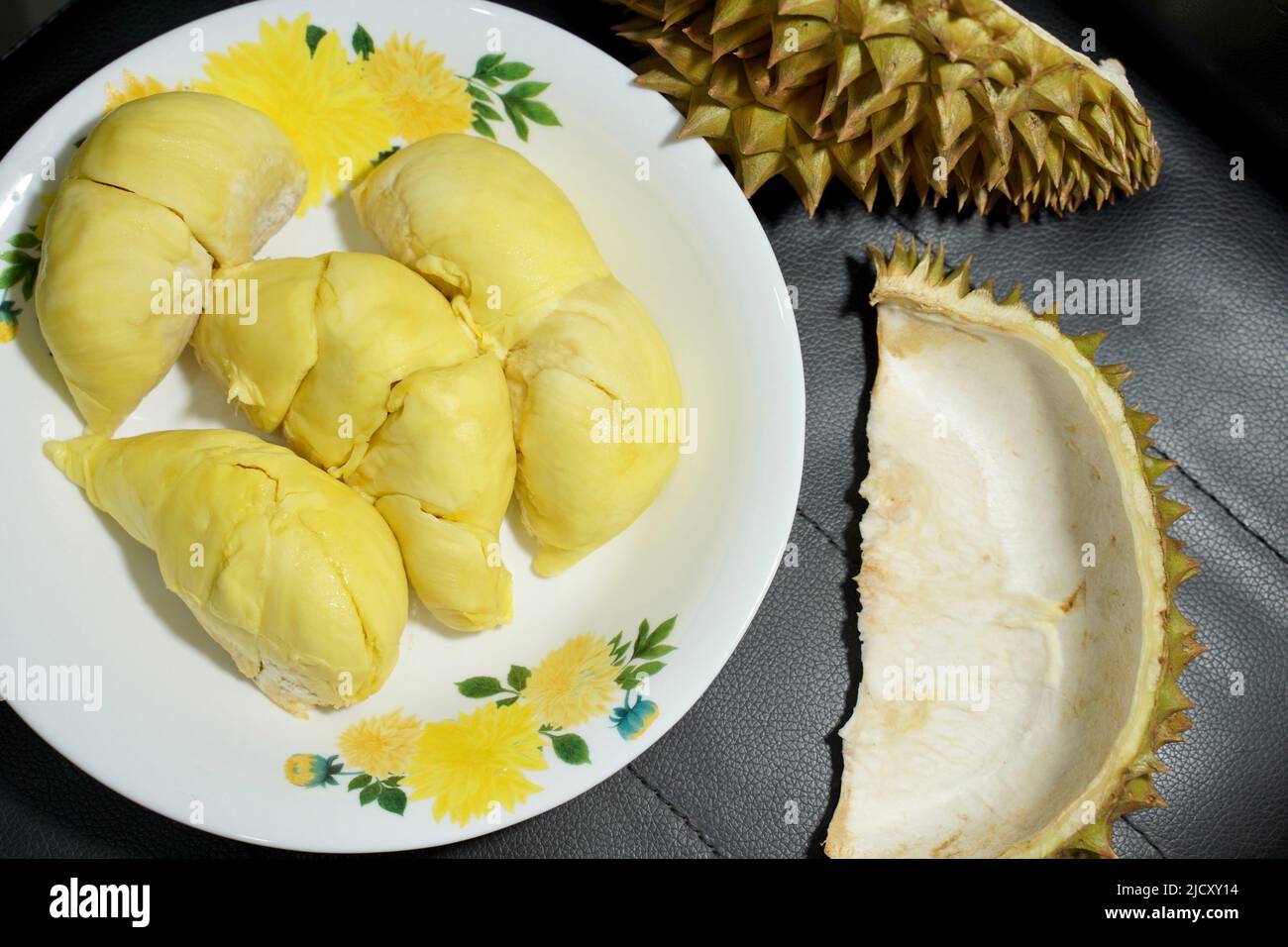 Fresh durian in packaging on white dish with durian peel on banner ...
