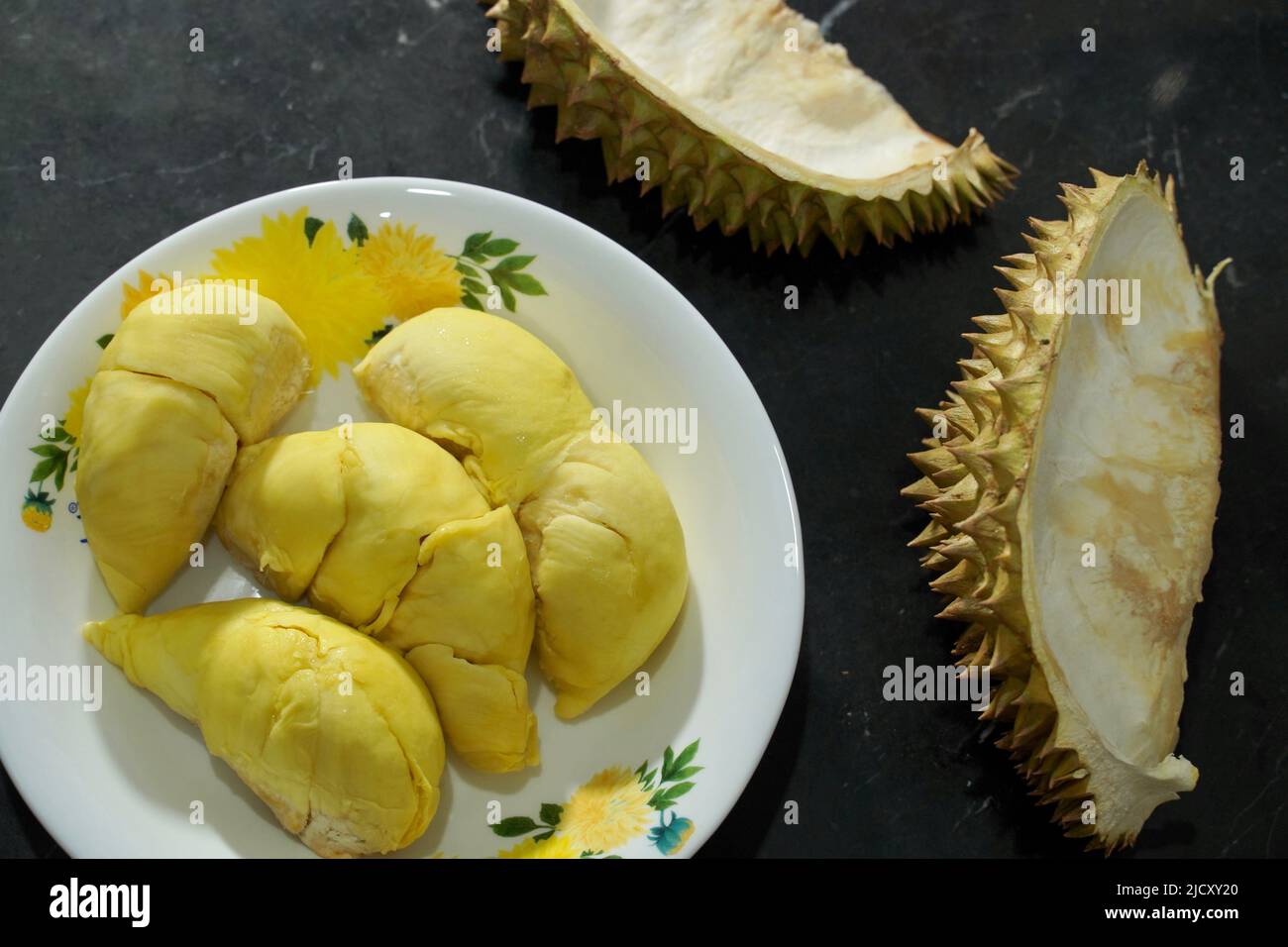 Fresh durian in packaging on white dish with durian peel on banner ...