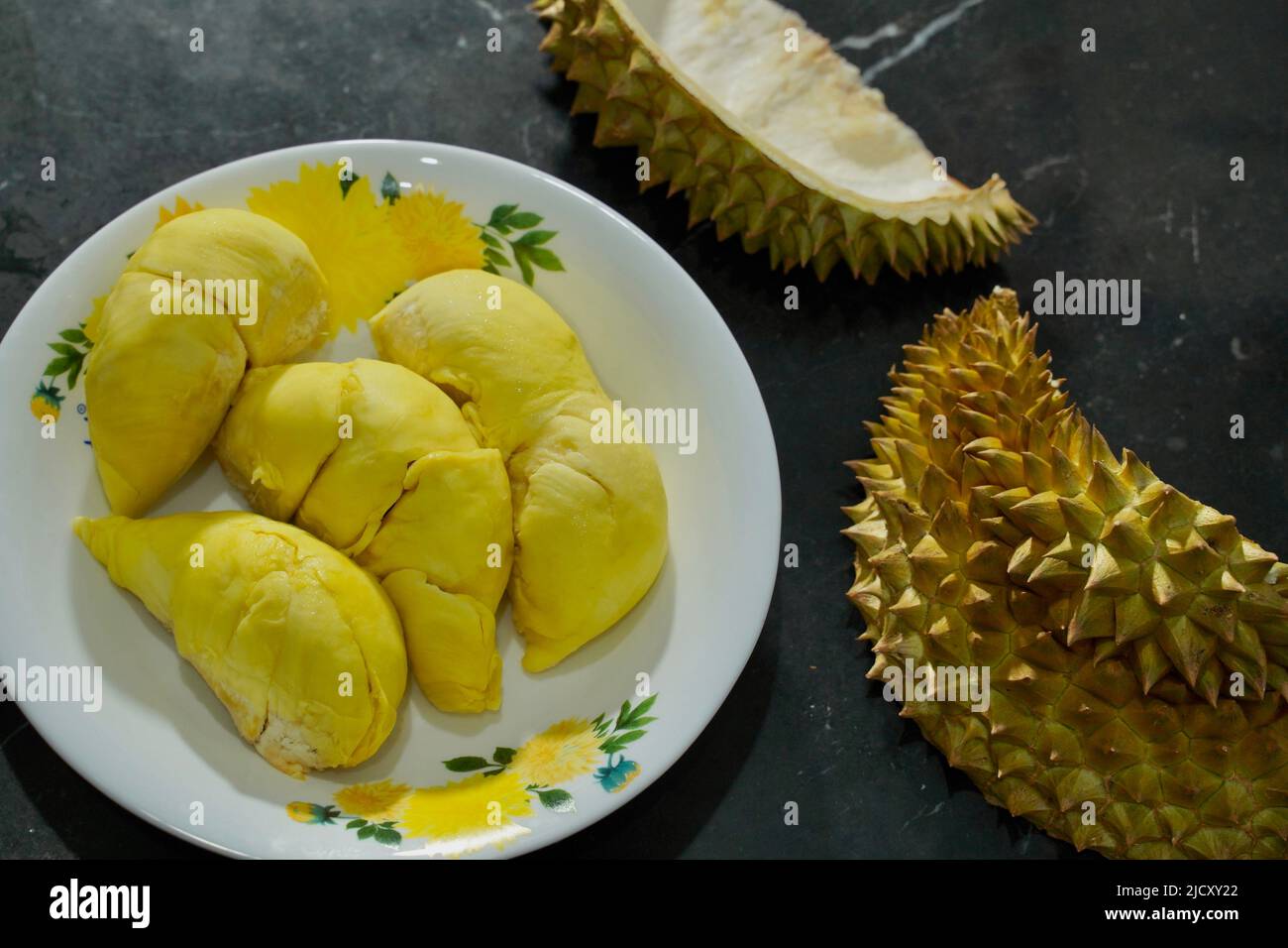 Fresh durian in packaging on white dish with durian peel on banner ...