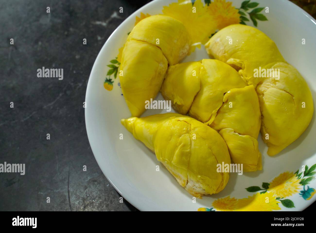 Fresh durian in packaging on white dish with durian peel on banner ...