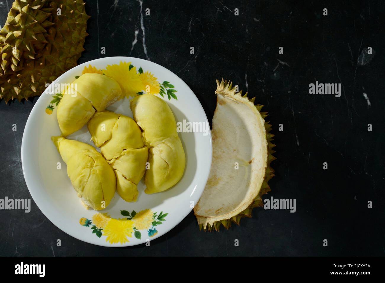 Fresh durian in packaging on white dish with durian peel on banner ...