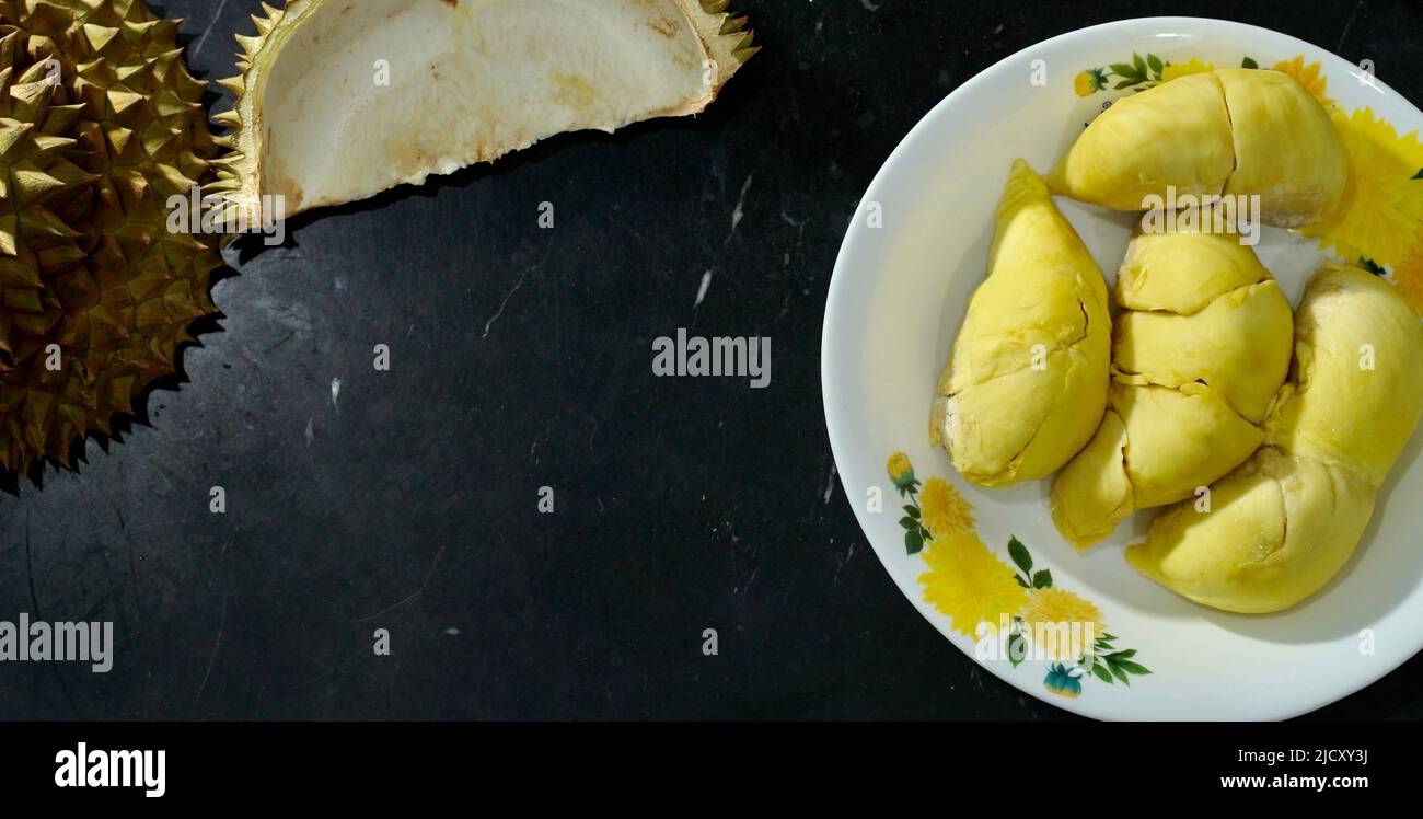 Fresh durian in packaging on white dish with durian peel on banner ...