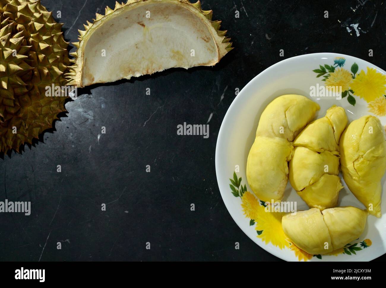Fresh durian in packaging on white dish with durian peel on banner ...