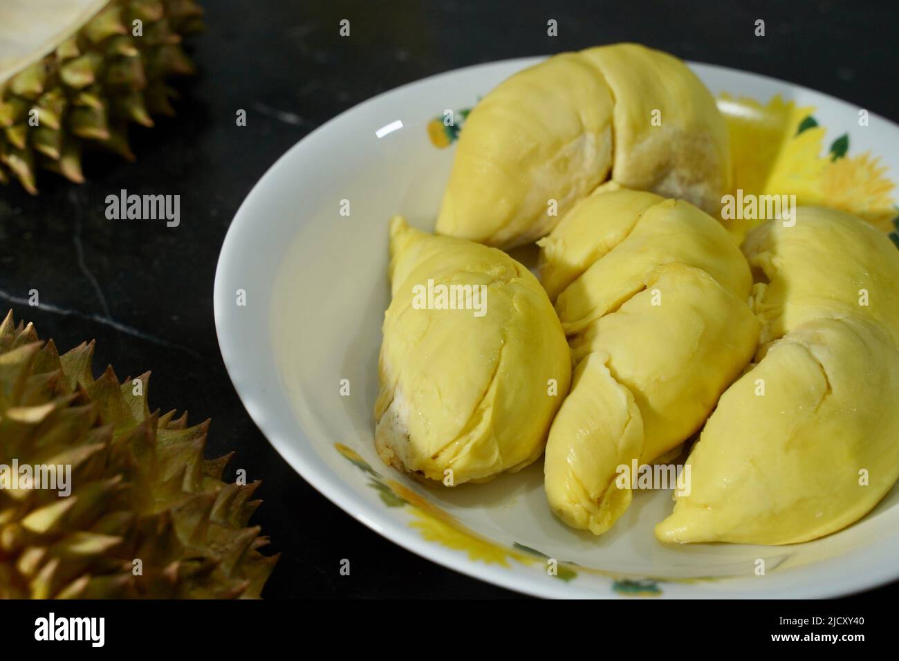 Fresh durian in packaging on white dish with durian peel on banner ...