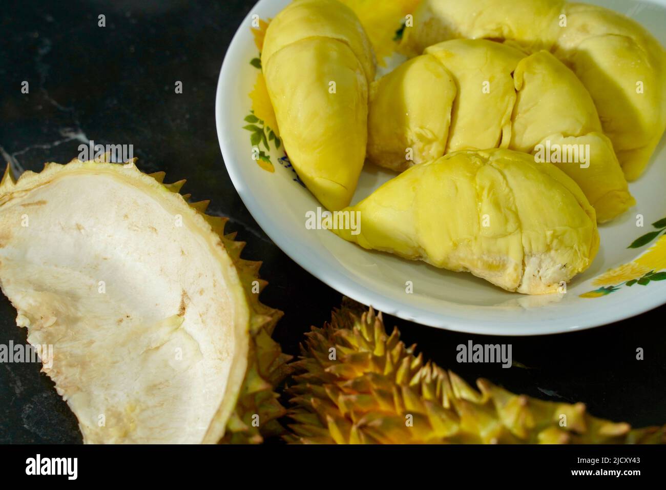 Fresh durian in packaging on white dish with durian peel on banner ...