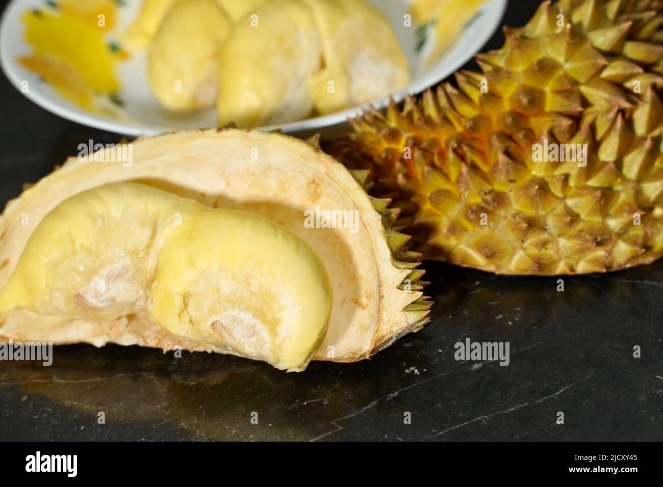 Fresh durian in packaging on white dish with durian peel on banner ...